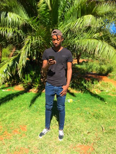 Jay Rsa | a man standing in the grass with his hands on a smart phone